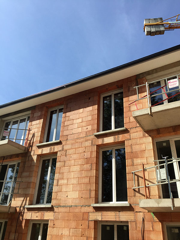 Construction de logements en Isère, façade en briques rouges avec ...